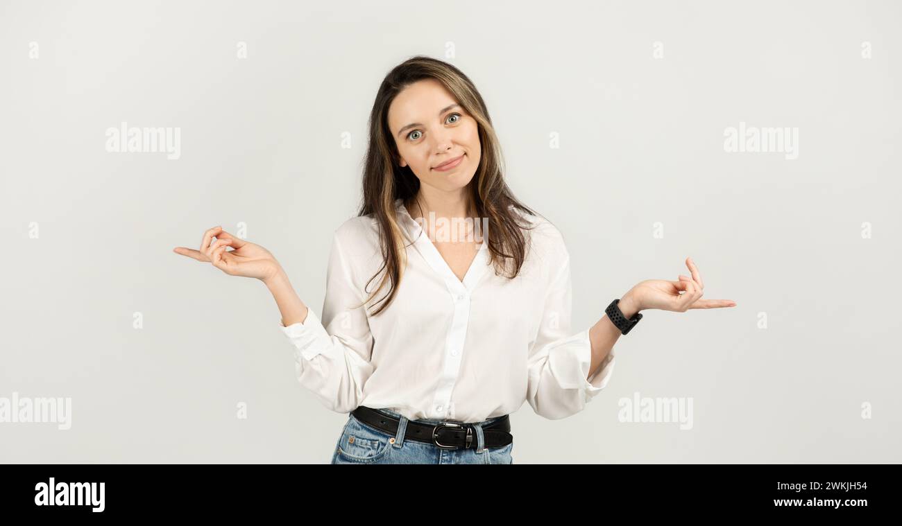 A young woman with long brown hair, wearing a white blouse and jeans ...