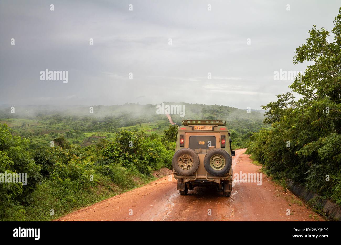 A 4x4 vehicle on a red earth road after heavy rain in wilderness near ...