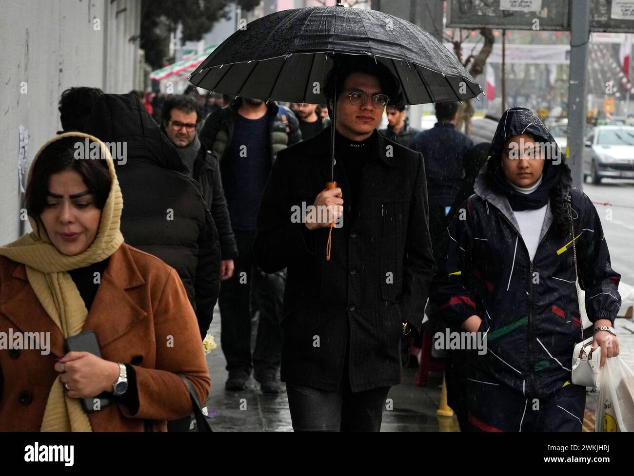 People walk in rainy weather in downtown Tehran, Iran, Wednesday, Feb ...