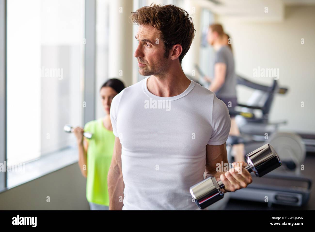 Group of young fit people exercising together during their workout in a ...