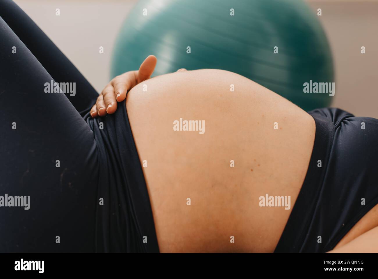 An expectant mother practicing prenatal exercises with a fitness ball ...