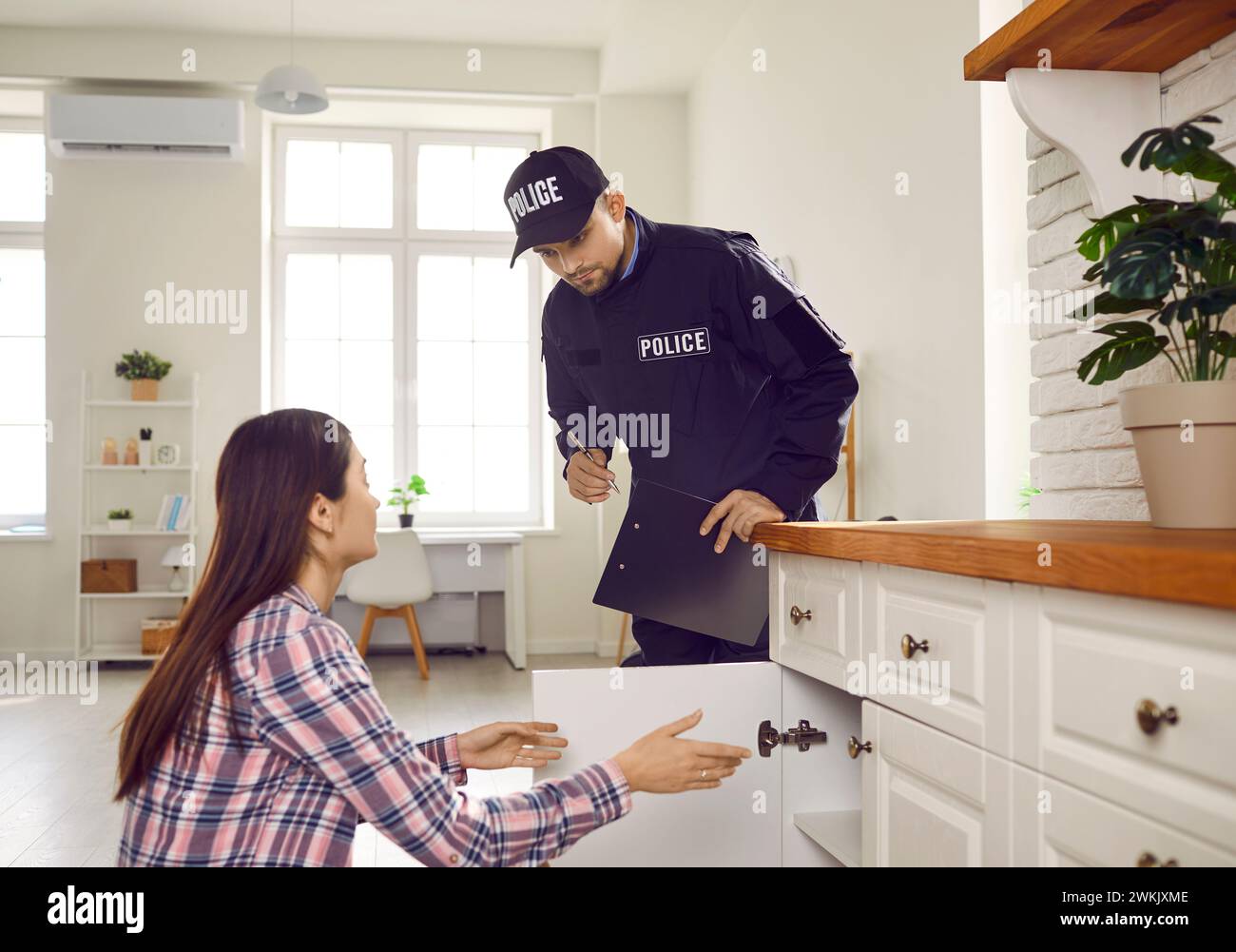 Woman house owner showing policeman her kitchen and telling what things ...
