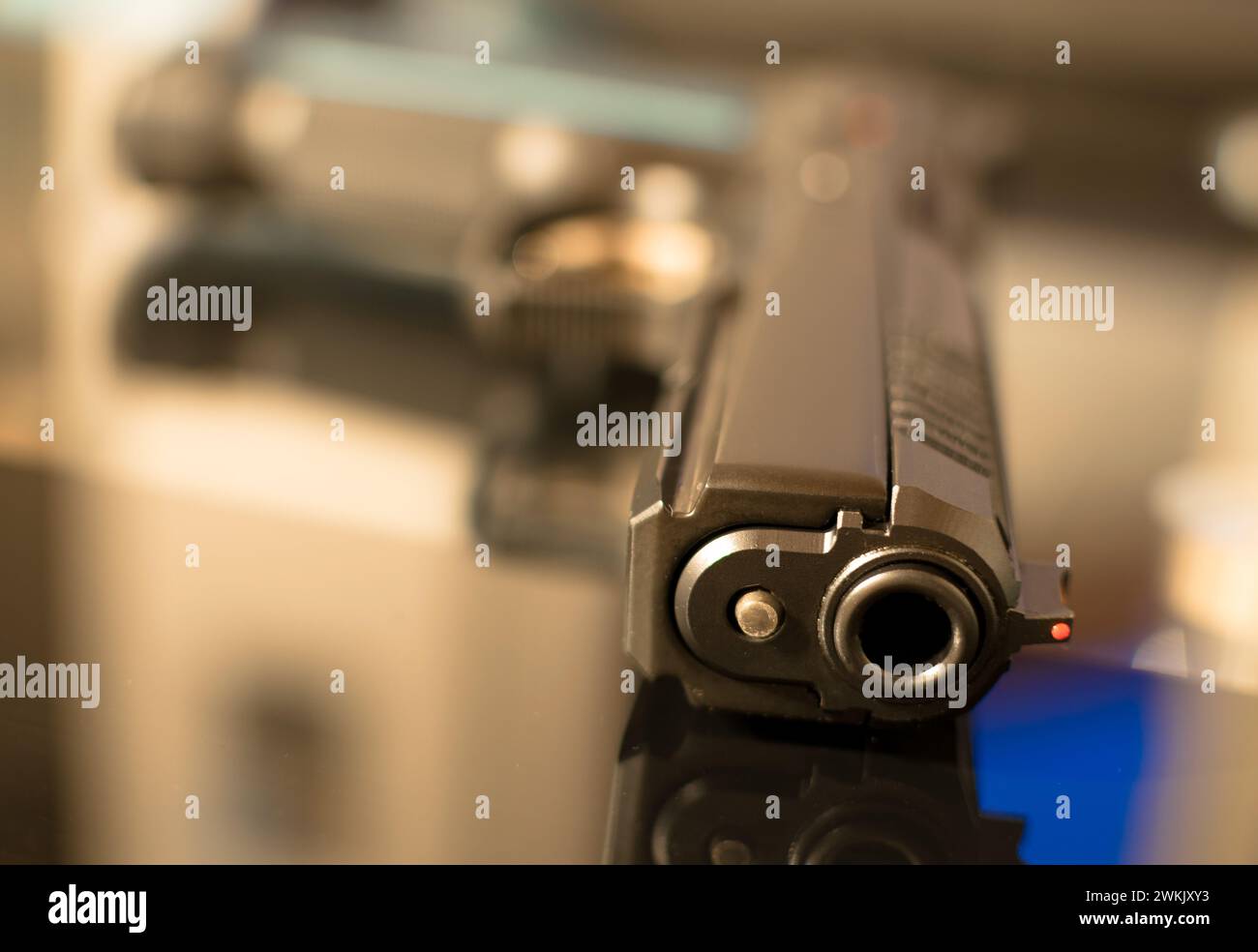 Close up of pistol on table pointing towards viewer. Front end of ...