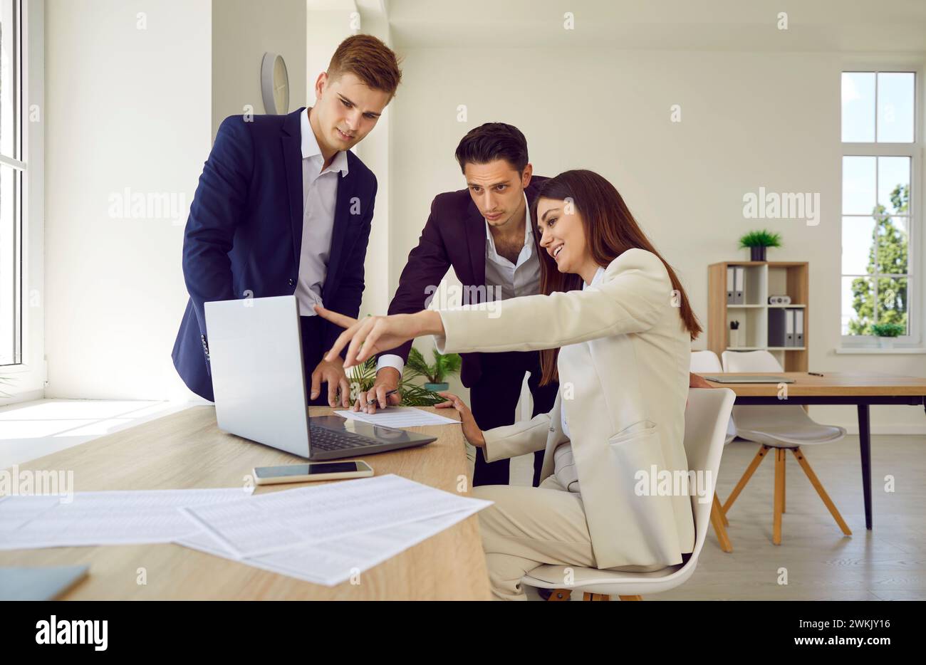 Company employees talking with colleagues on workplace in office ...