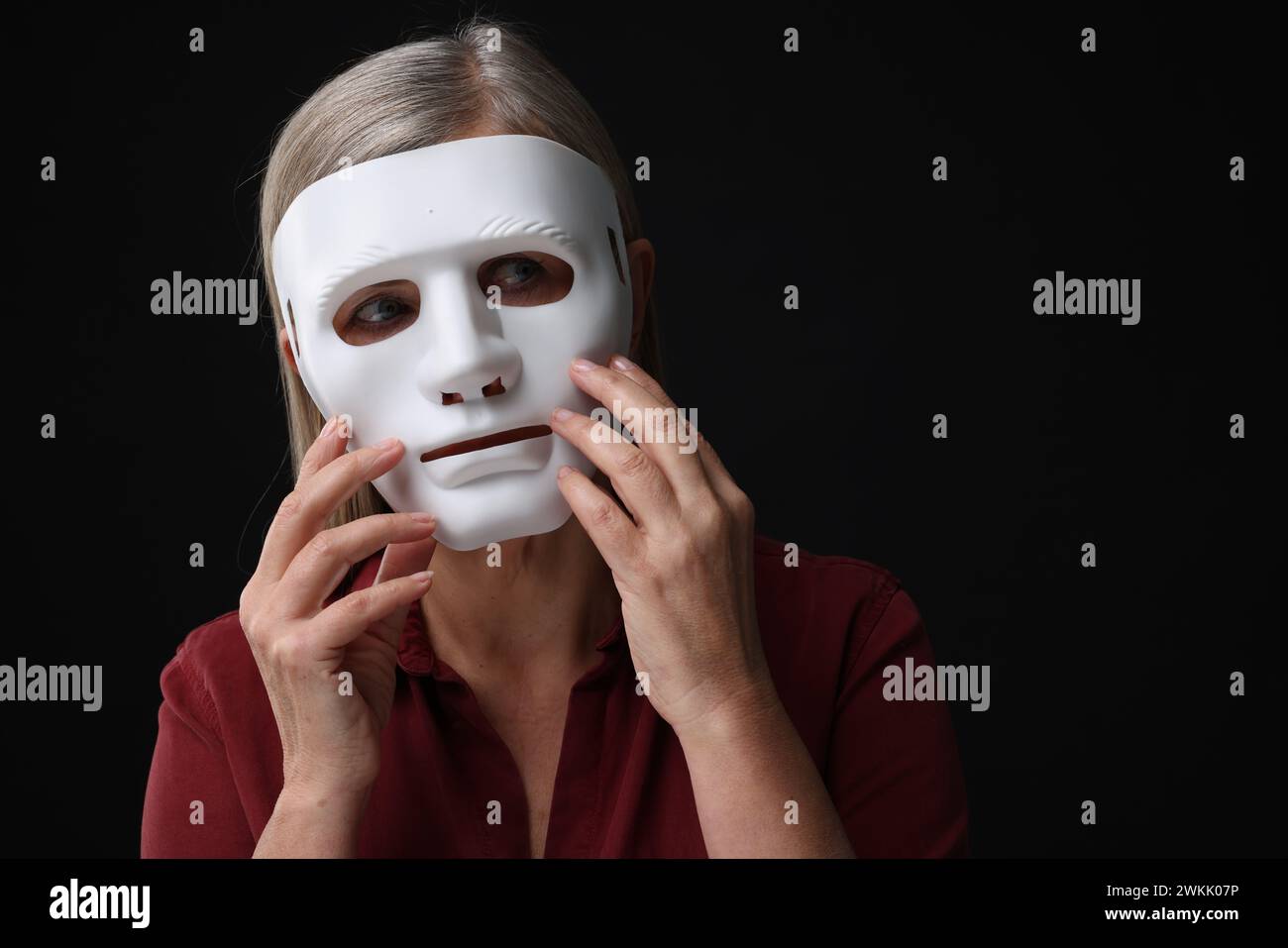 Multiple personality concept. Woman in mask on black background, space ...
