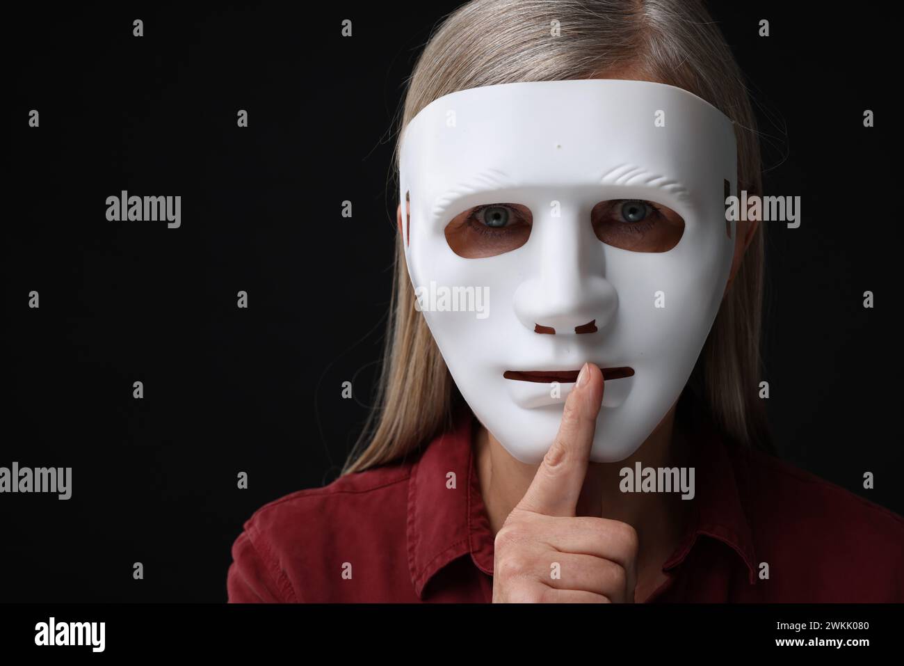 Multiple personality concept. Woman in mask showing hush gesture on ...