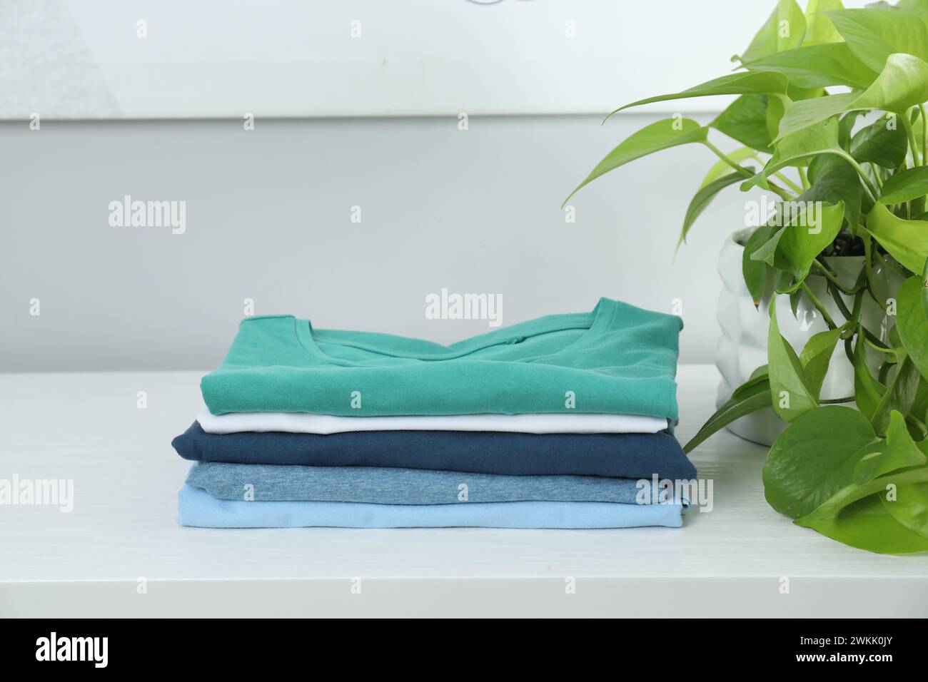 Sorting and organizing. Stack of different folded clothes on white ...