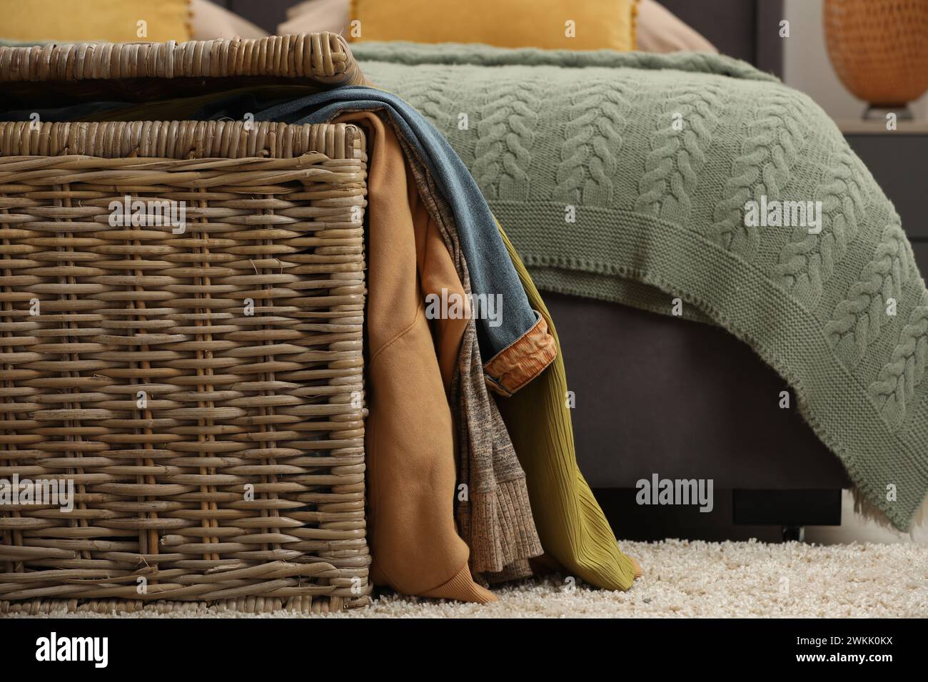 Sorting and organizing. Basket with many different clothes in room ...