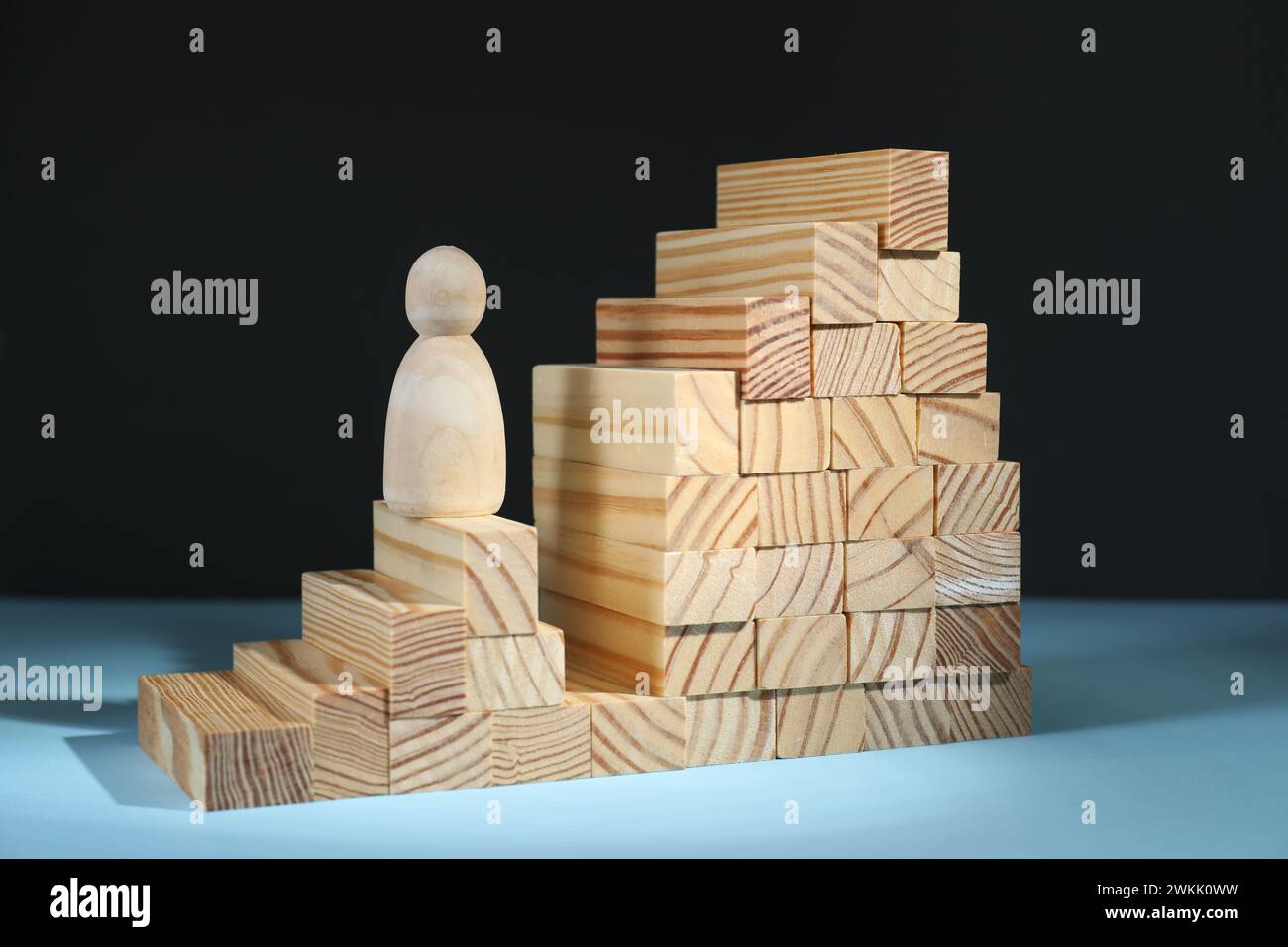 Stairs of blocks with gap as barrier and wooden human figure on light ...