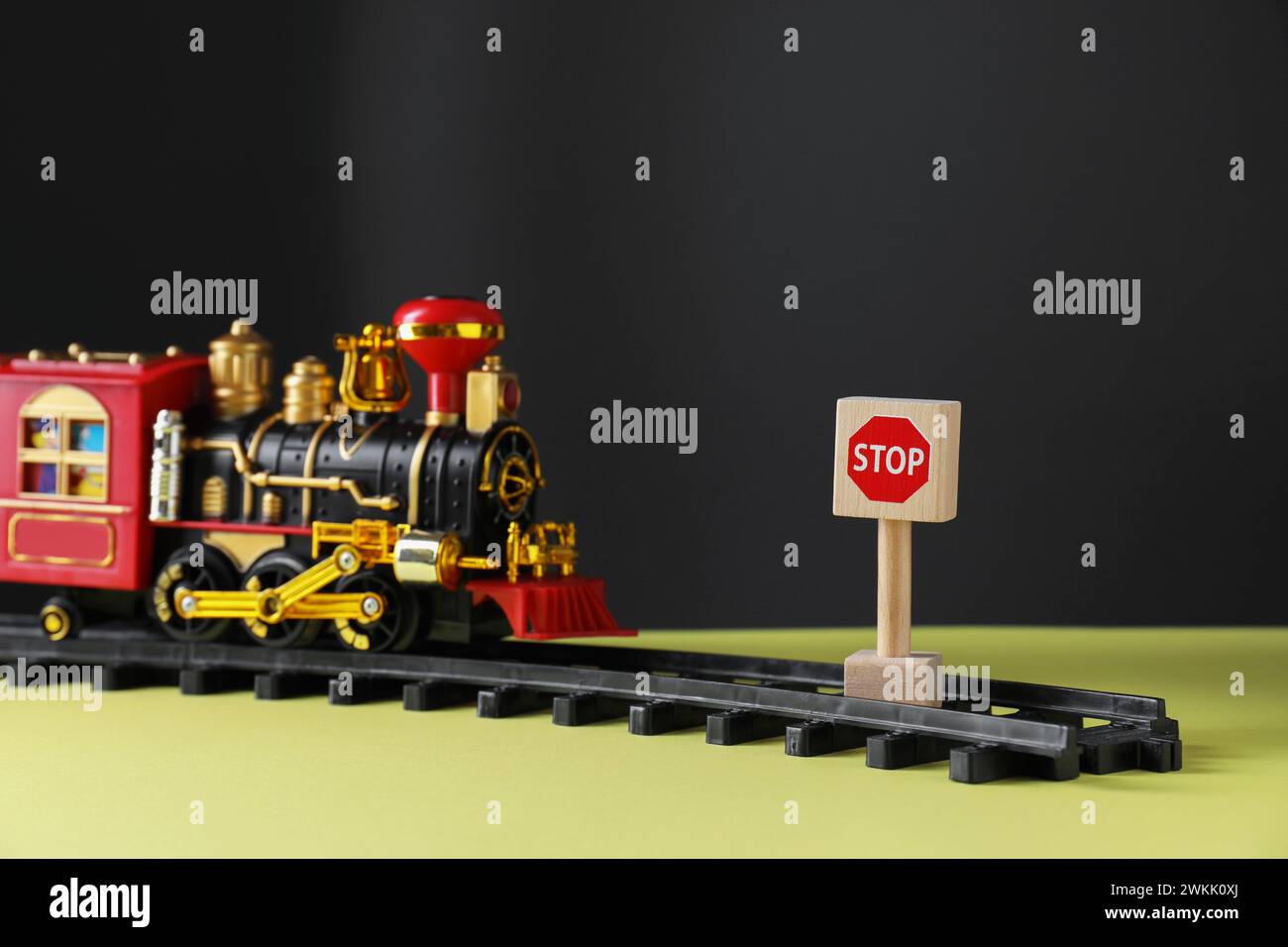 Road Stop sign as barrier blocking way for toy train on yellow surface ...