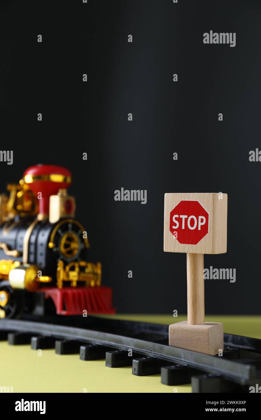 Road Stop sign as barrier blocking way for toy train on yellow surface ...
