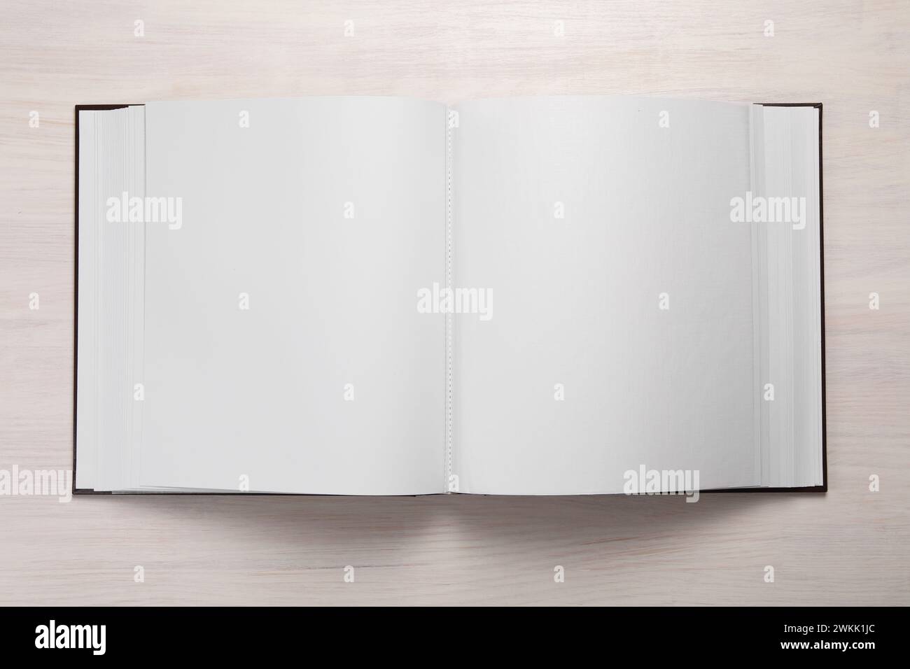 One open photo album on wooden table, top view Stock Photo - Alamy