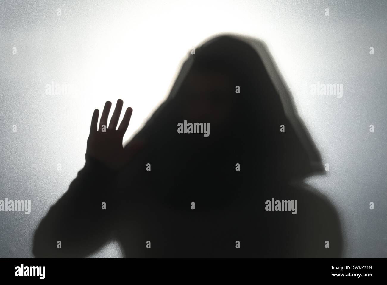 Silhouette of ghost behind glass against grey background Stock Photo ...