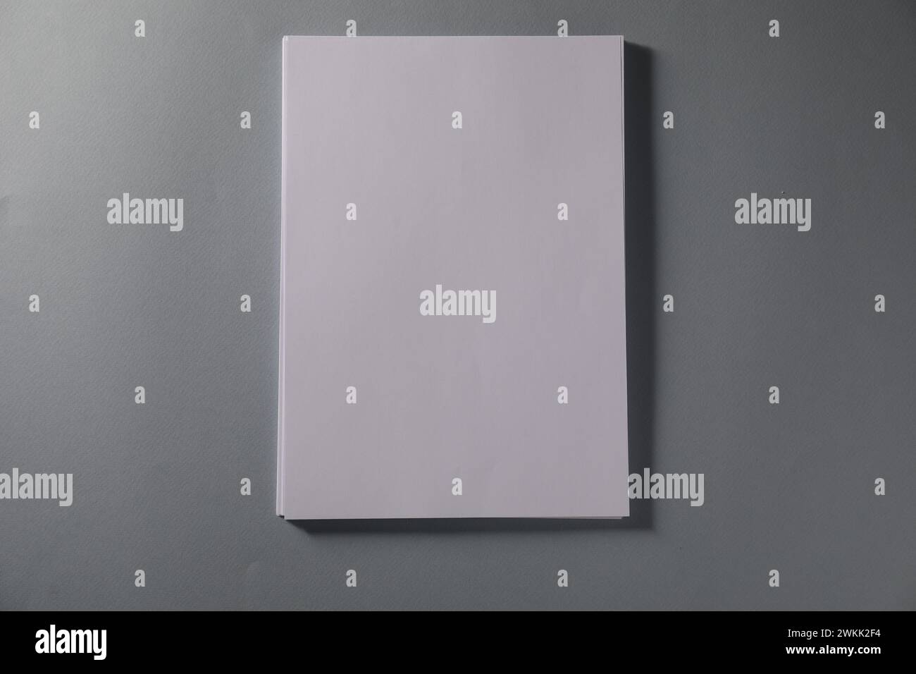 Stack of blank paper sheets on grey background, top view. Space for ...