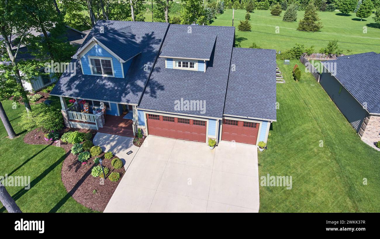 Aerial View of Blue Suburban Home with Red Garage Doors in Serene ...