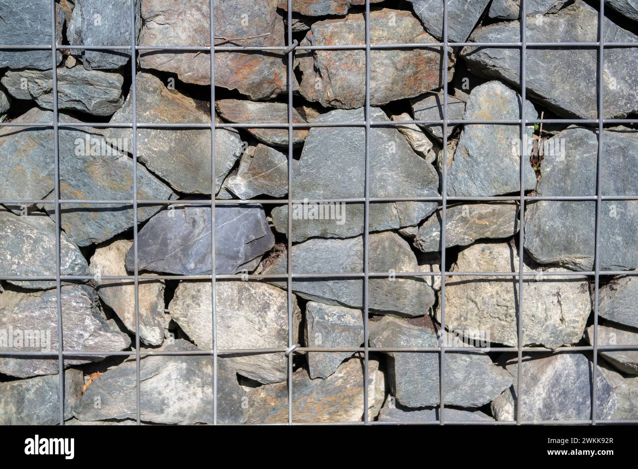 Natural stone wall with iron grille Stock Photo - Alamy