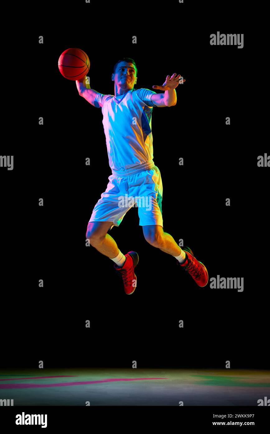 Athlete man basketball player passing ball in mid-air in action against ...