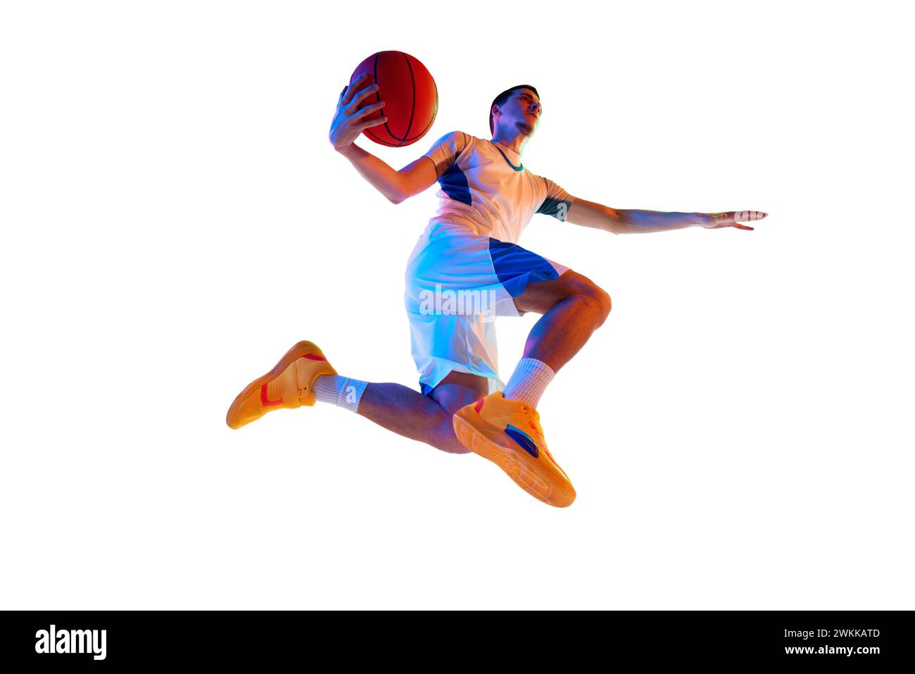 Athletic man doing basketball dunk in motion against white studio ...