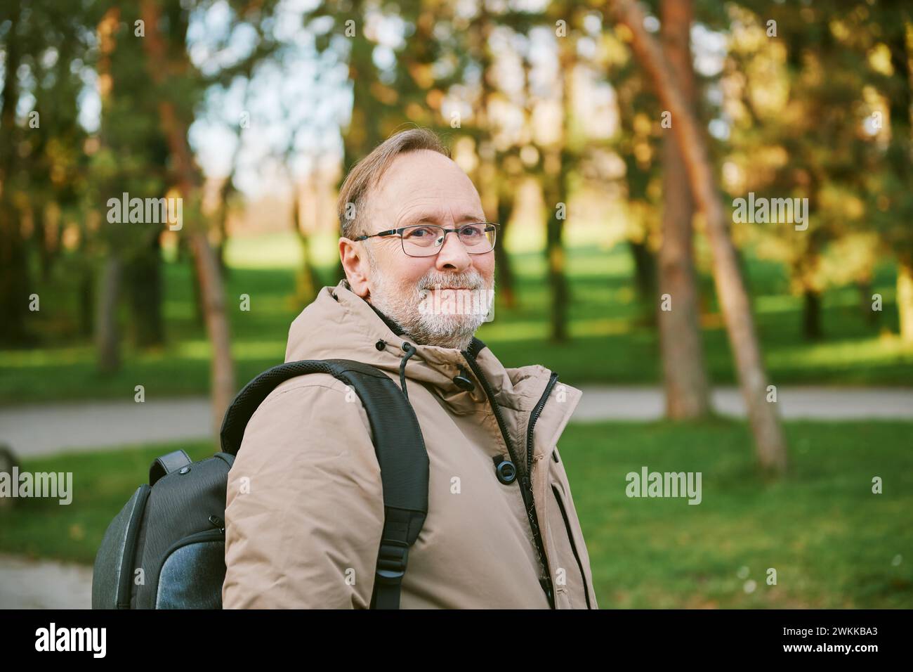 Outdoor portrait of handsome middle age man in green park, wearing warm ...