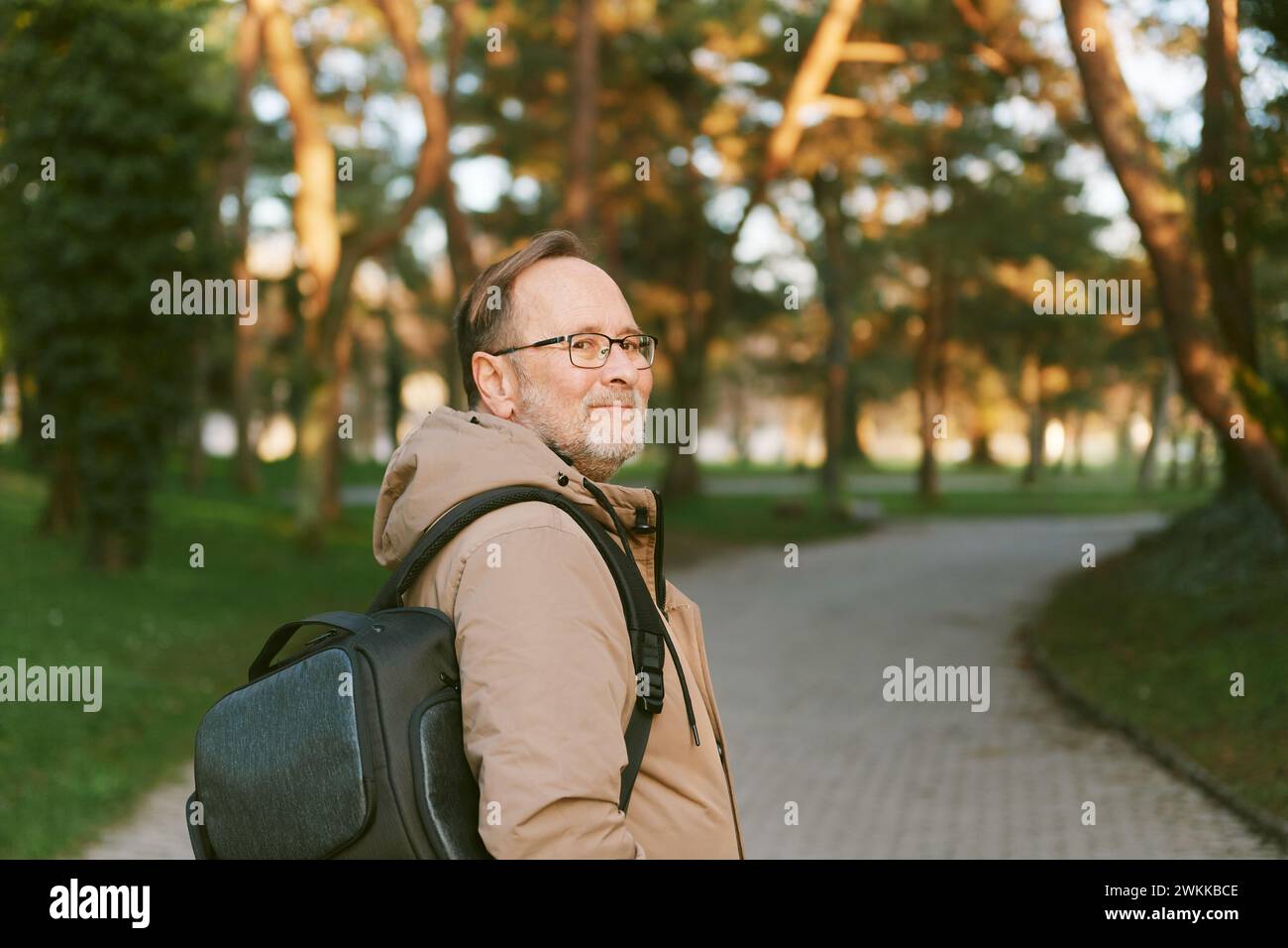 Outdoor portrait of handsome middle age man in green park, wearing warm ...