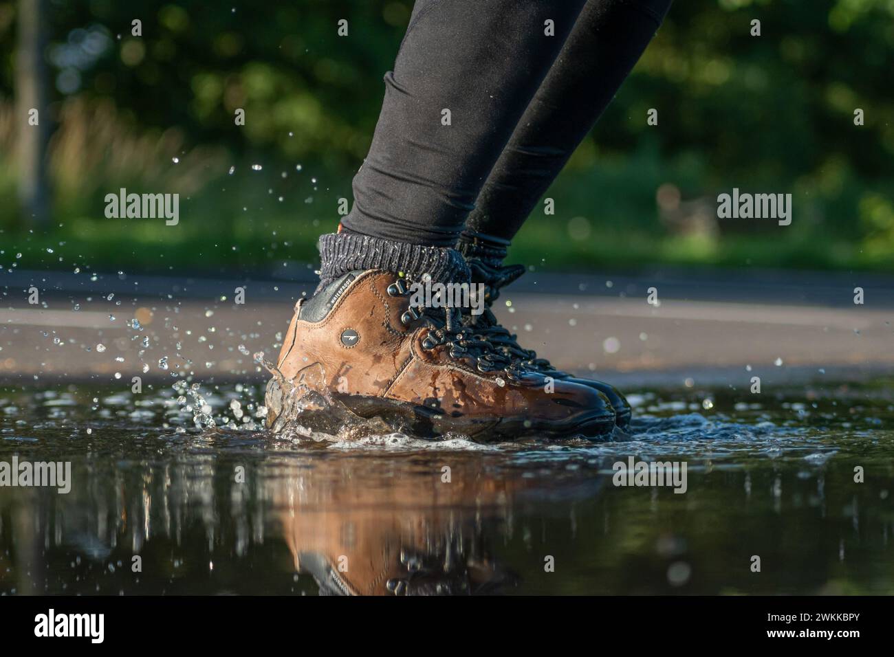 Walking Boots Splashing in Puddle Stock Photo - Alamy