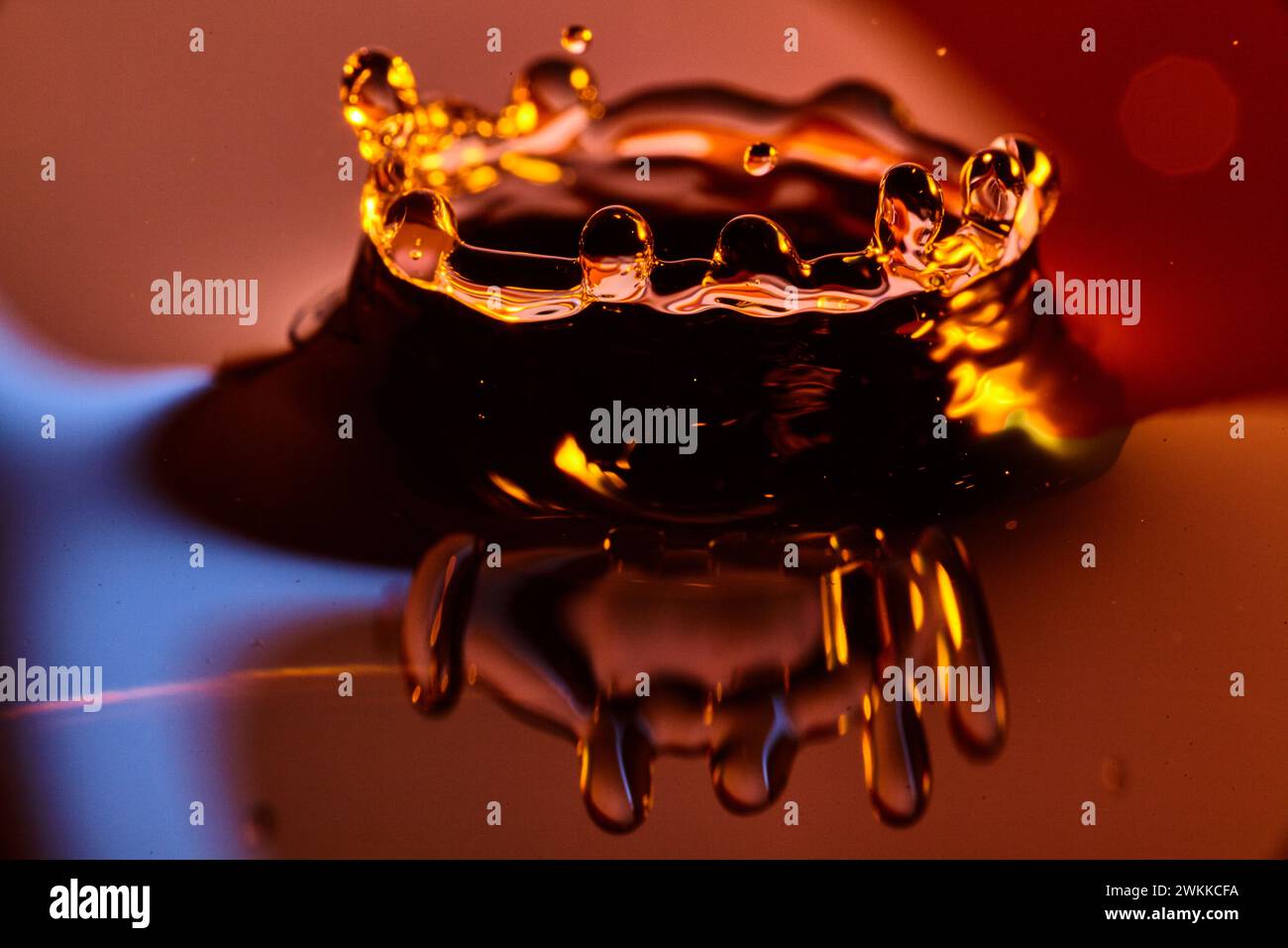 Illuminated Water Splash Crown in Warm Tones Close-Up Stock Photo - Alamy