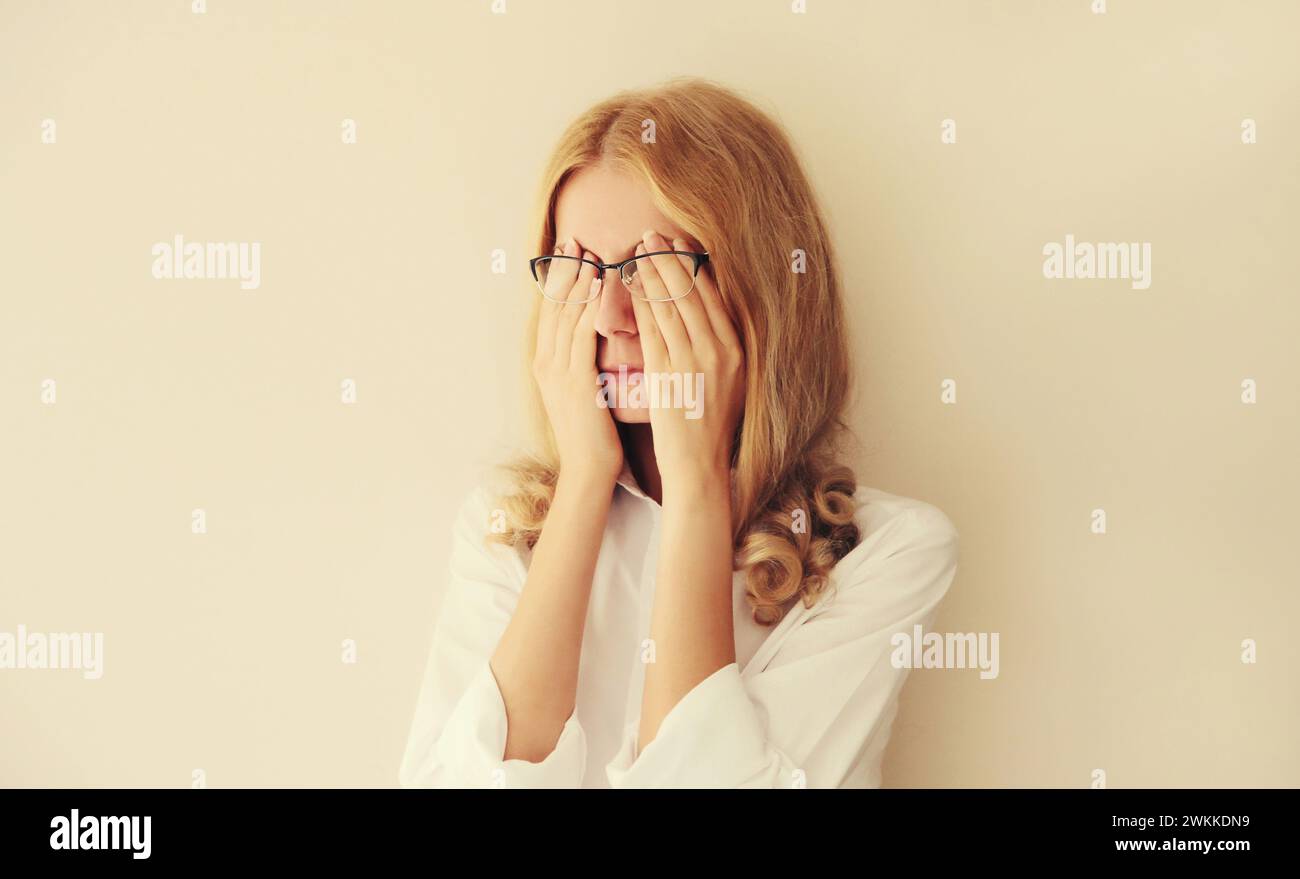Tired overworked young woman employee rubbing her eyes suffering from ...
