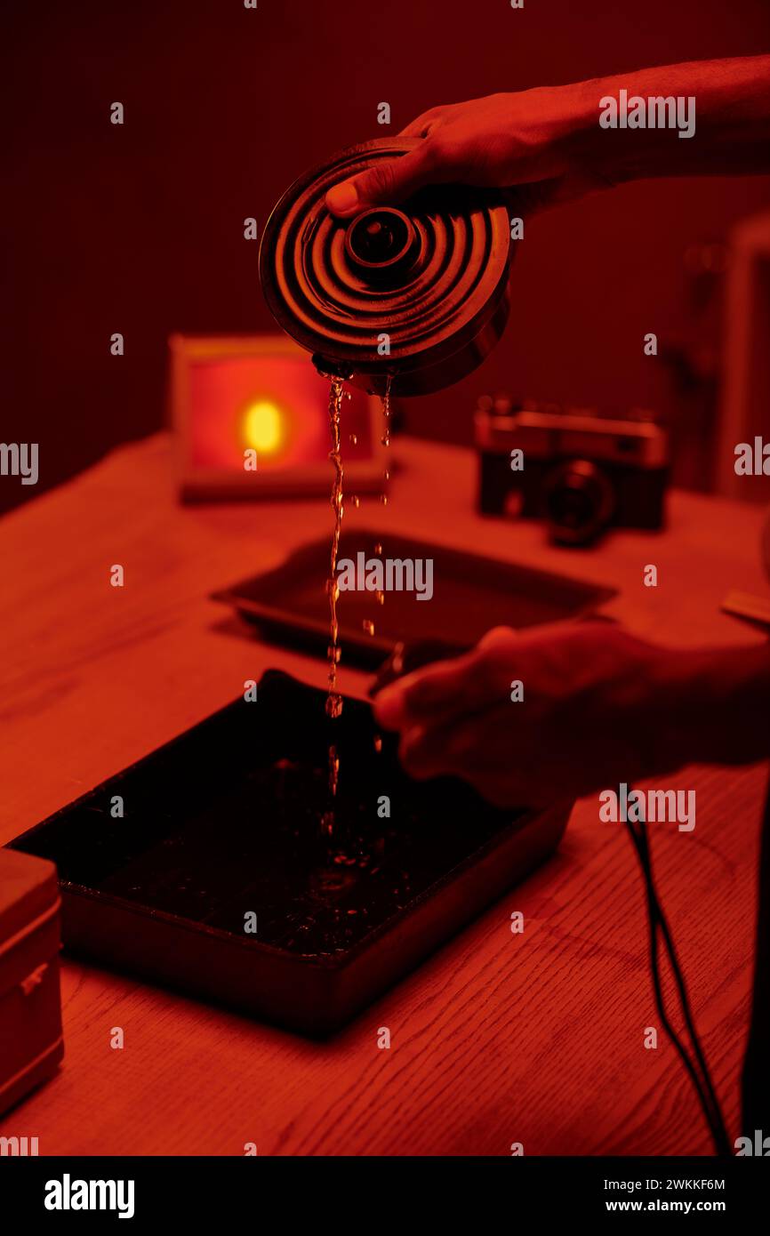 cropped photo of photographer pouring developer liquid for film ...