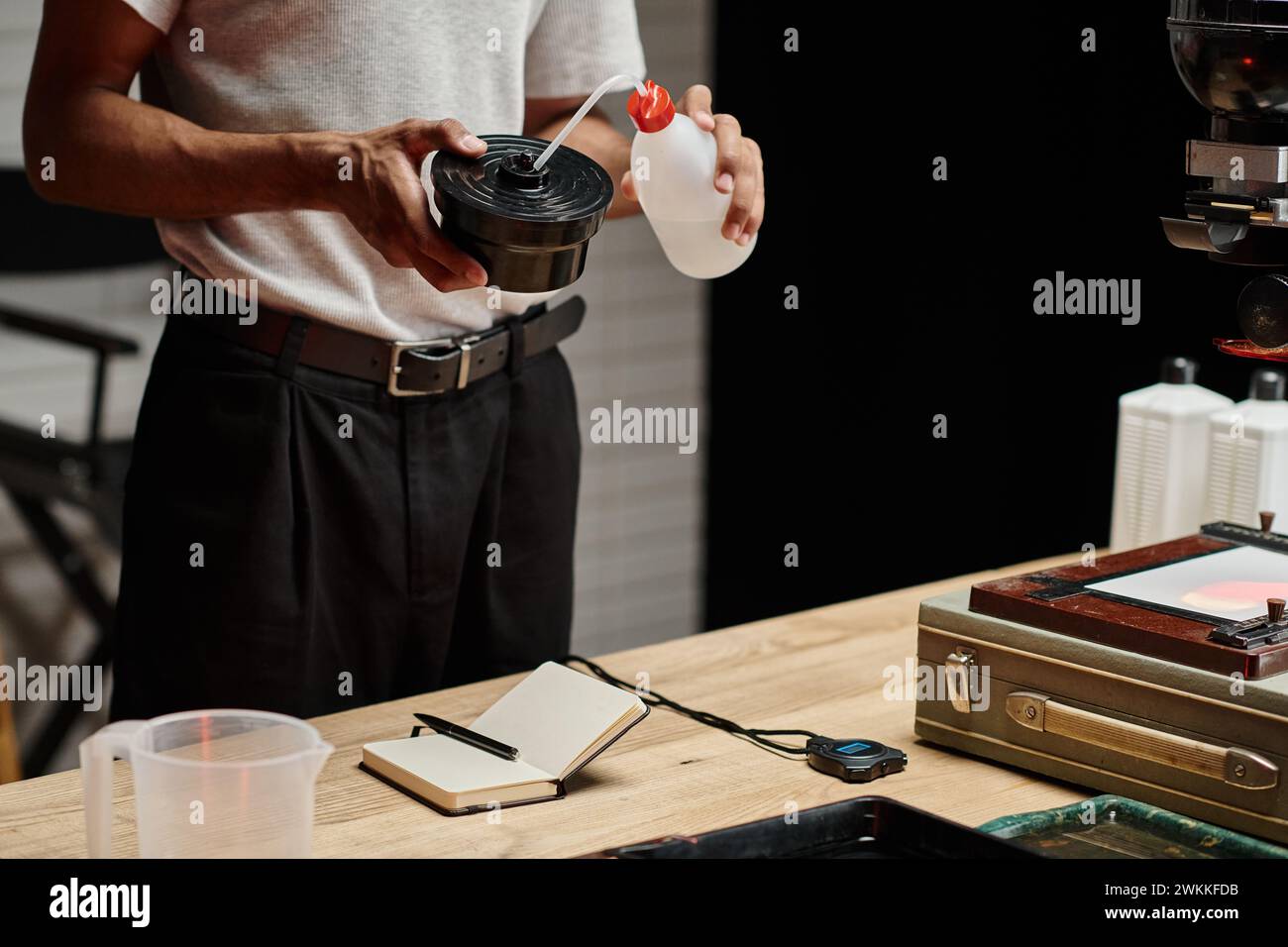 cropped photo of african american photographer pouring chemical ...