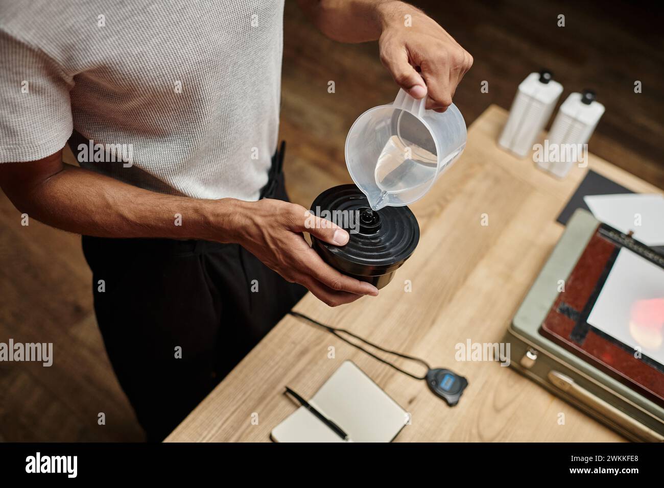 cropped view of african american photographer pouring chemical solution ...