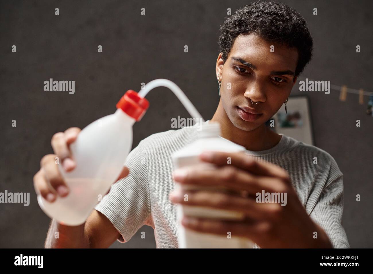 dark skinned photographer preparing film development solution in ...