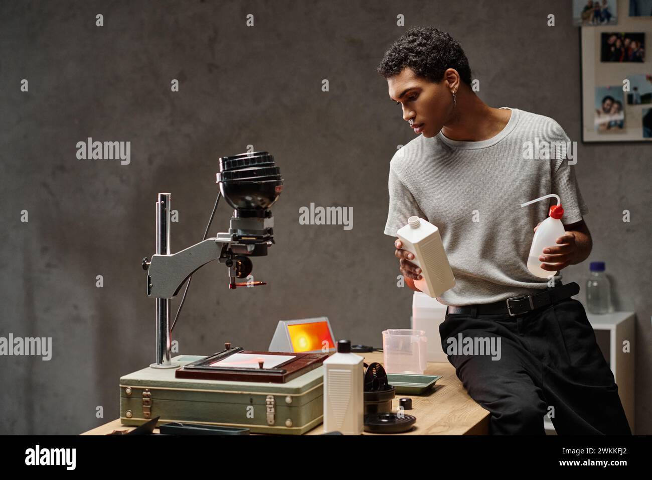 A focused african american man carefully measuring photo chemicals in a ...