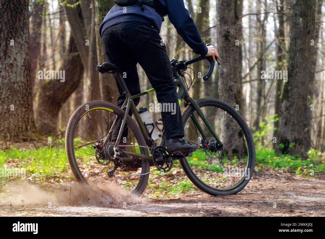 Cyclist on a gravel bike. A cyclist rides along a forest path drifting ...