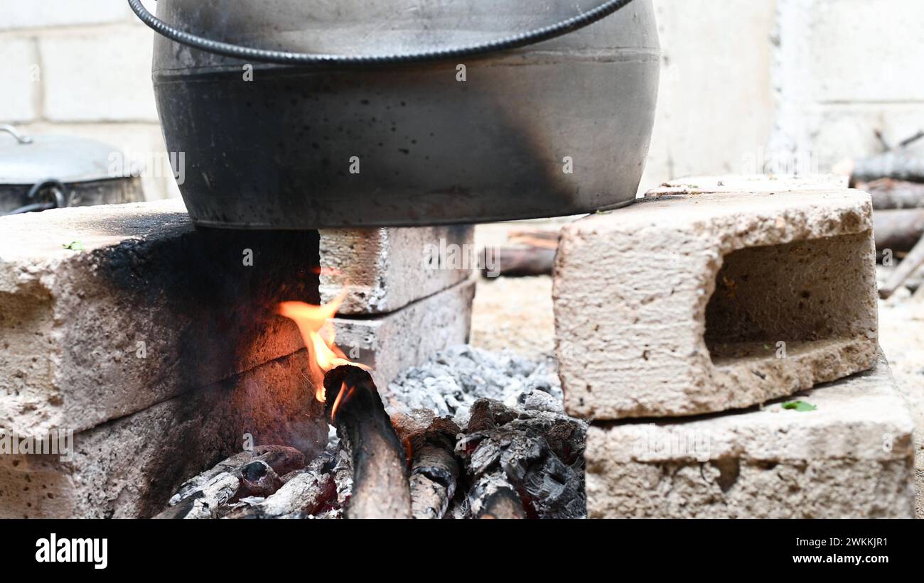 Holiday food fire cooking pot firewood. Preparing food on fire. Cast ...