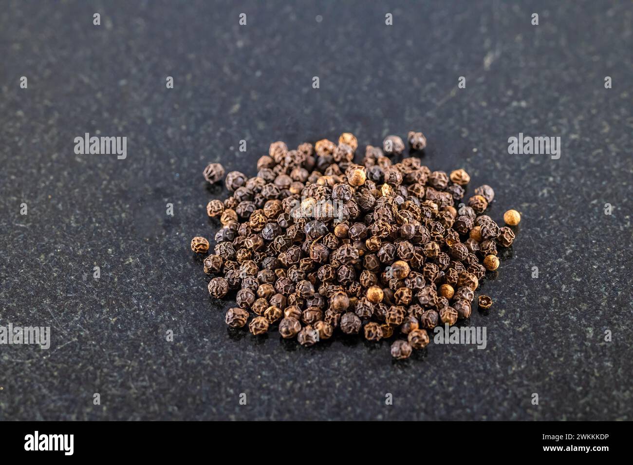 A close up view of dried pepper corns on a dark marble platter Stock ...