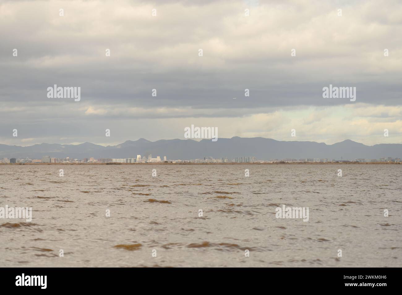 The Valencia skyline rises in the distance, viewed across the choppy ...