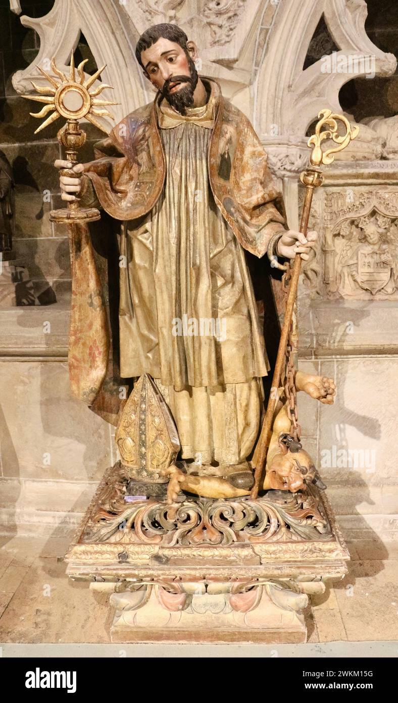 Painted wooden sculpture of a saint in robes in the Colegiate of San ...