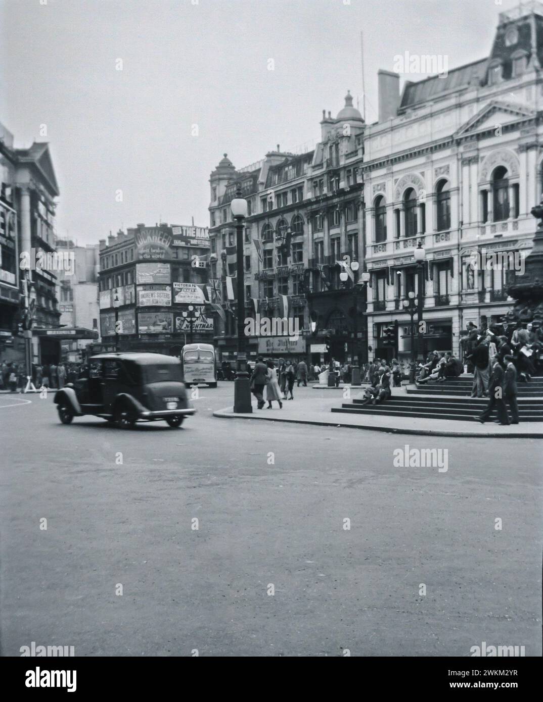London's Piccadilly Circus in the 1950s. A London taxi and a bus drive away from the area ...