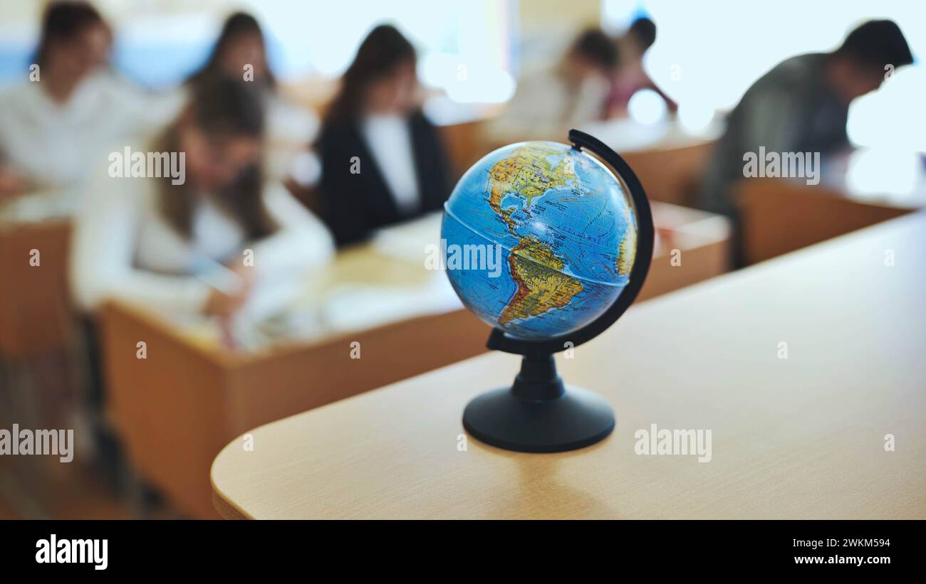 A globe of the world with textbooks in the background of a lesson in a ...