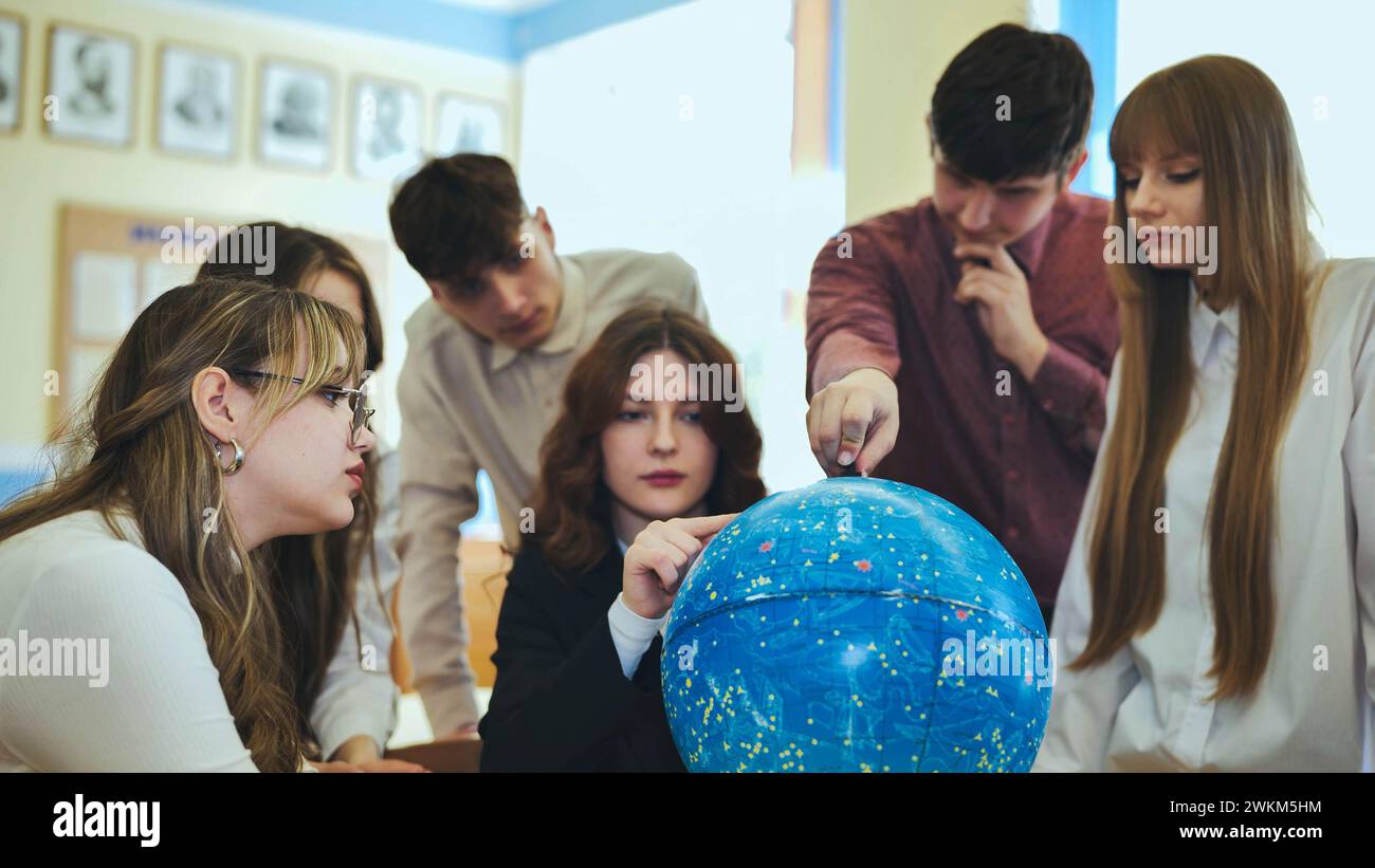 Students look at a globe of the starry sky in a classroom at school ...