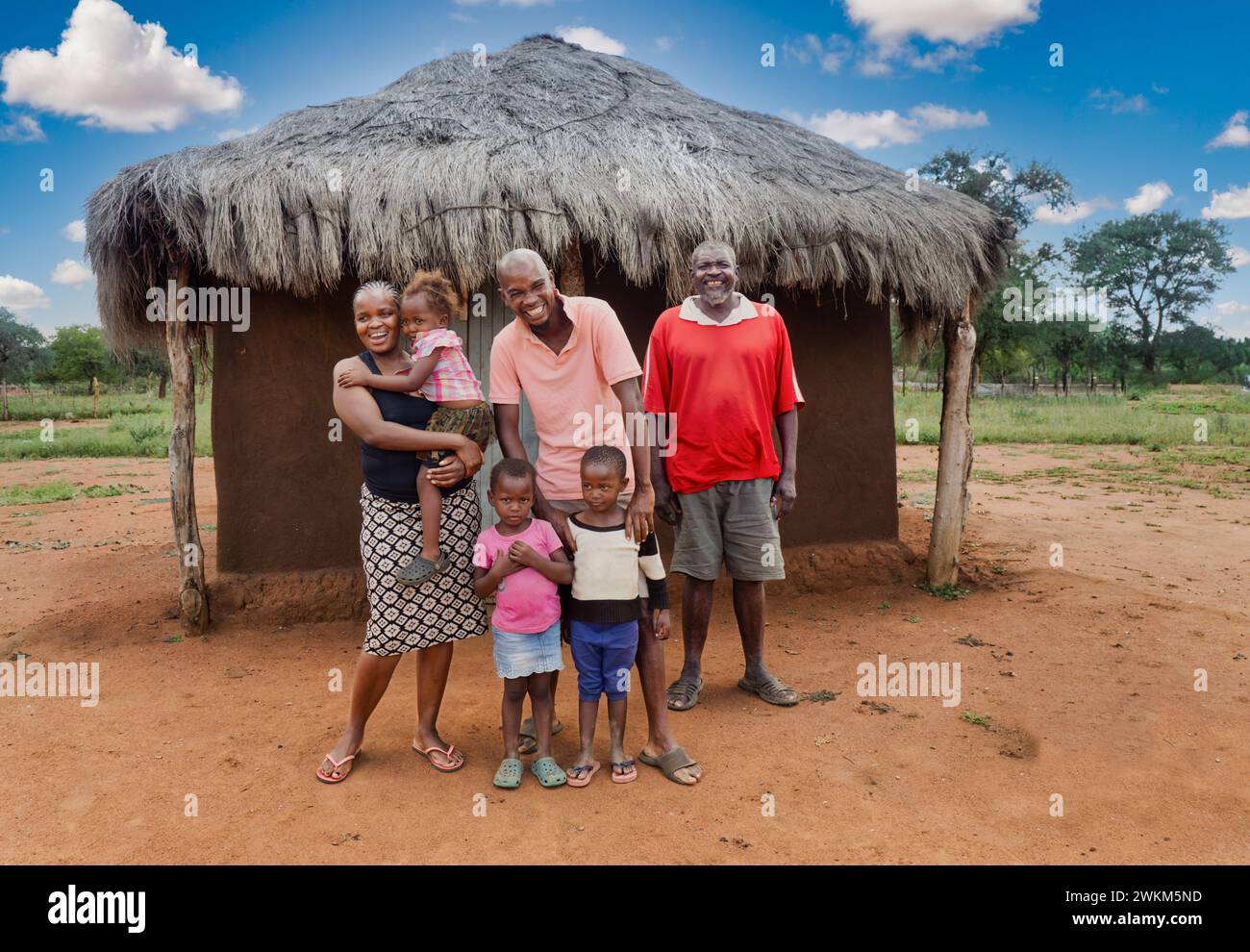 village happy extended multi generation african family in front of the mud hut with thatched ...