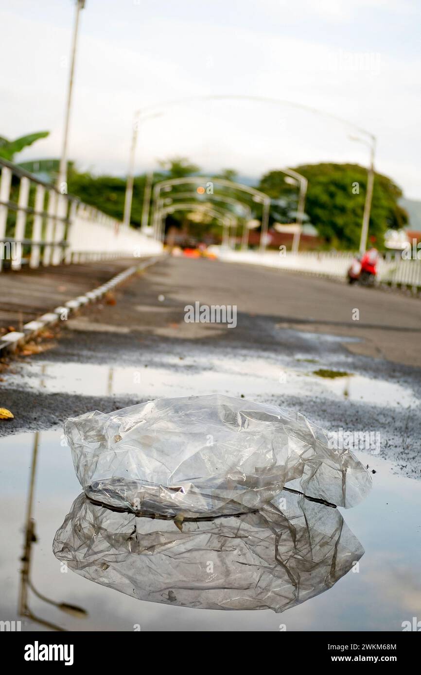 Transparent plastic trash in a puddle on the street Stock Photo - Alamy