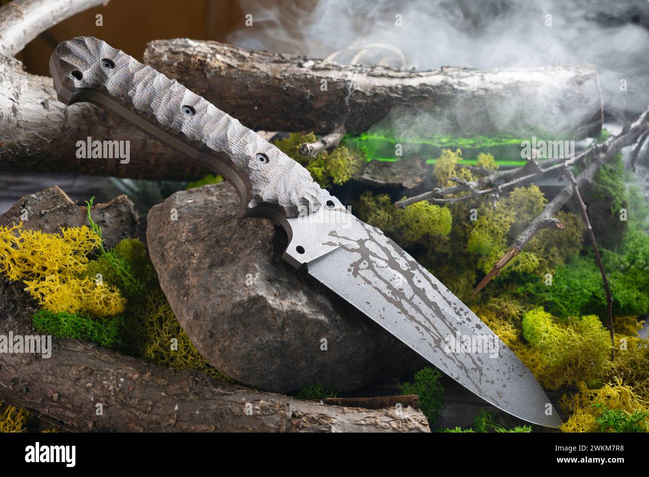 Military tactical knife lie on nature background. Stone, moss, trunk ...