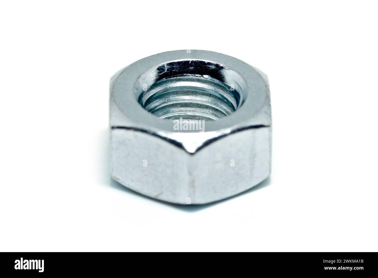 Close up of a single silver coloured hex nut isolated against a white ...