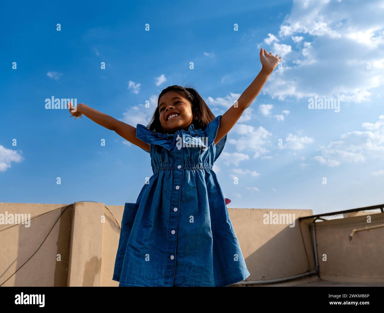 A radiant young girl throws her arms wide open Stock Photo - Alamy