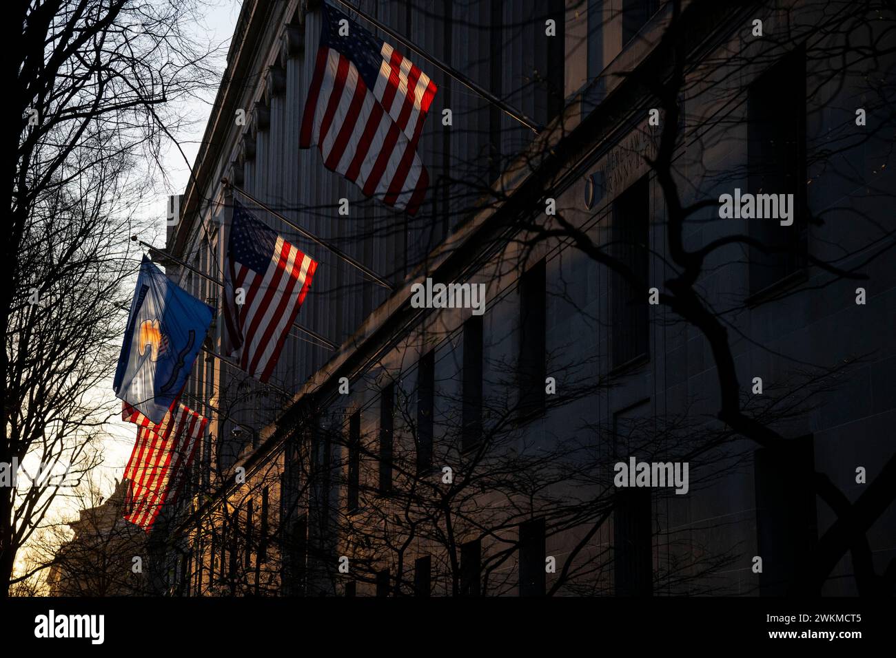 Washington, USA. 21st Feb, 2024. Sunlight illuminates flags on the U.S ...