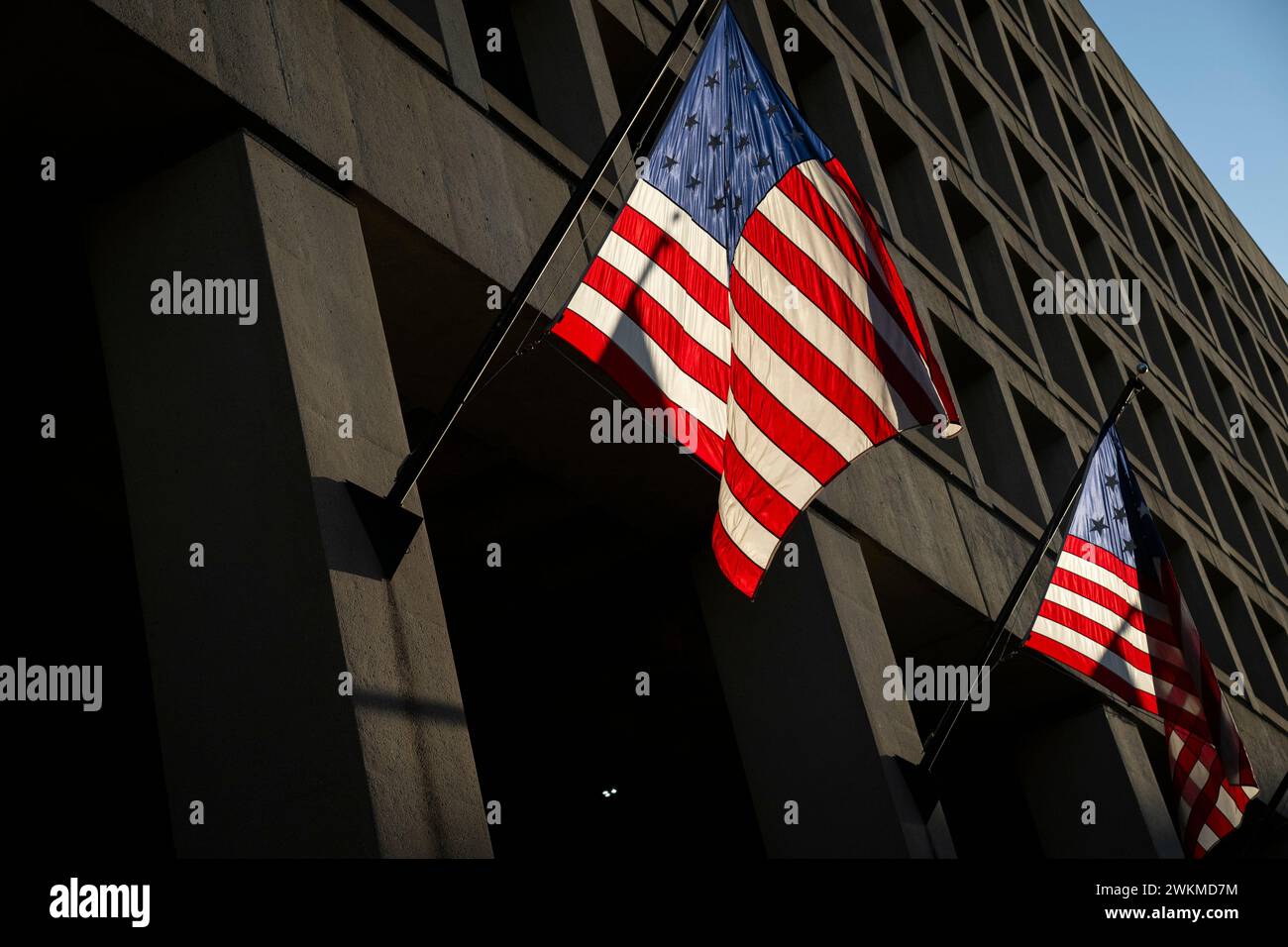 Washington, USA. 21st Feb, 2024. Sunlight illuminates flags at the U.S ...