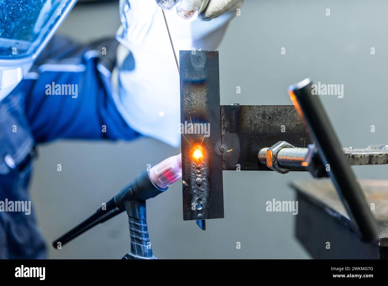 Welder worker welding a pieces of metal in the industrial factory ...