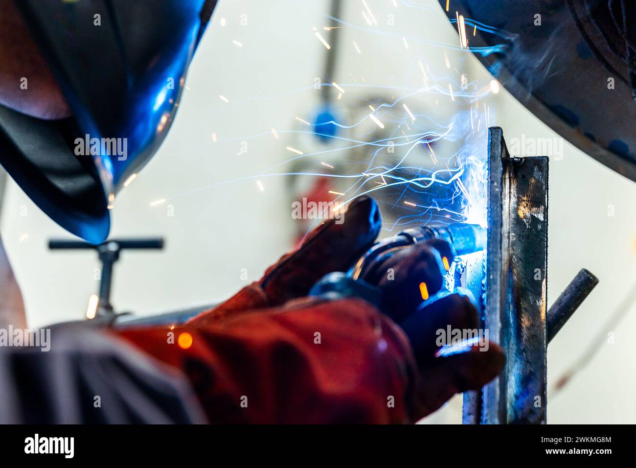 Welder worker welding a pieces of metal in the industrial factory ...