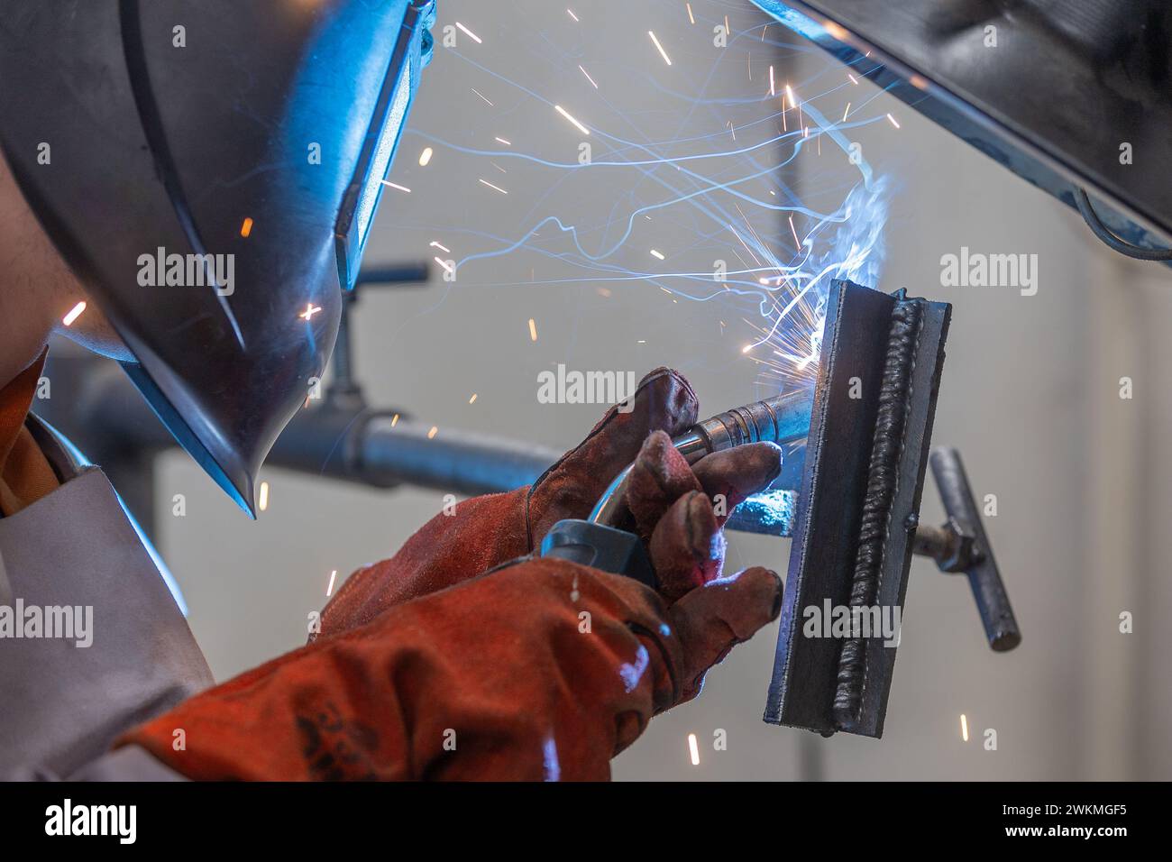 Welder man welding a metal, using a blowtorch, electric arc, or other ...